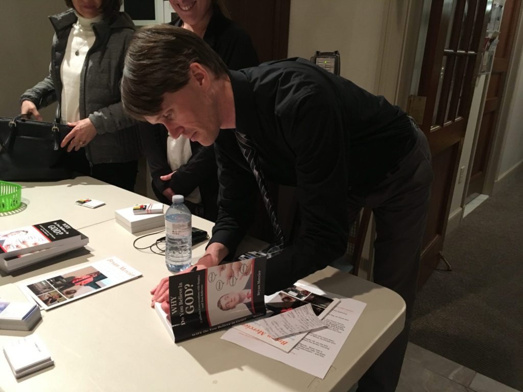 Catholic author and speaker Bryan Mercier signs a copy of his book, Why ...