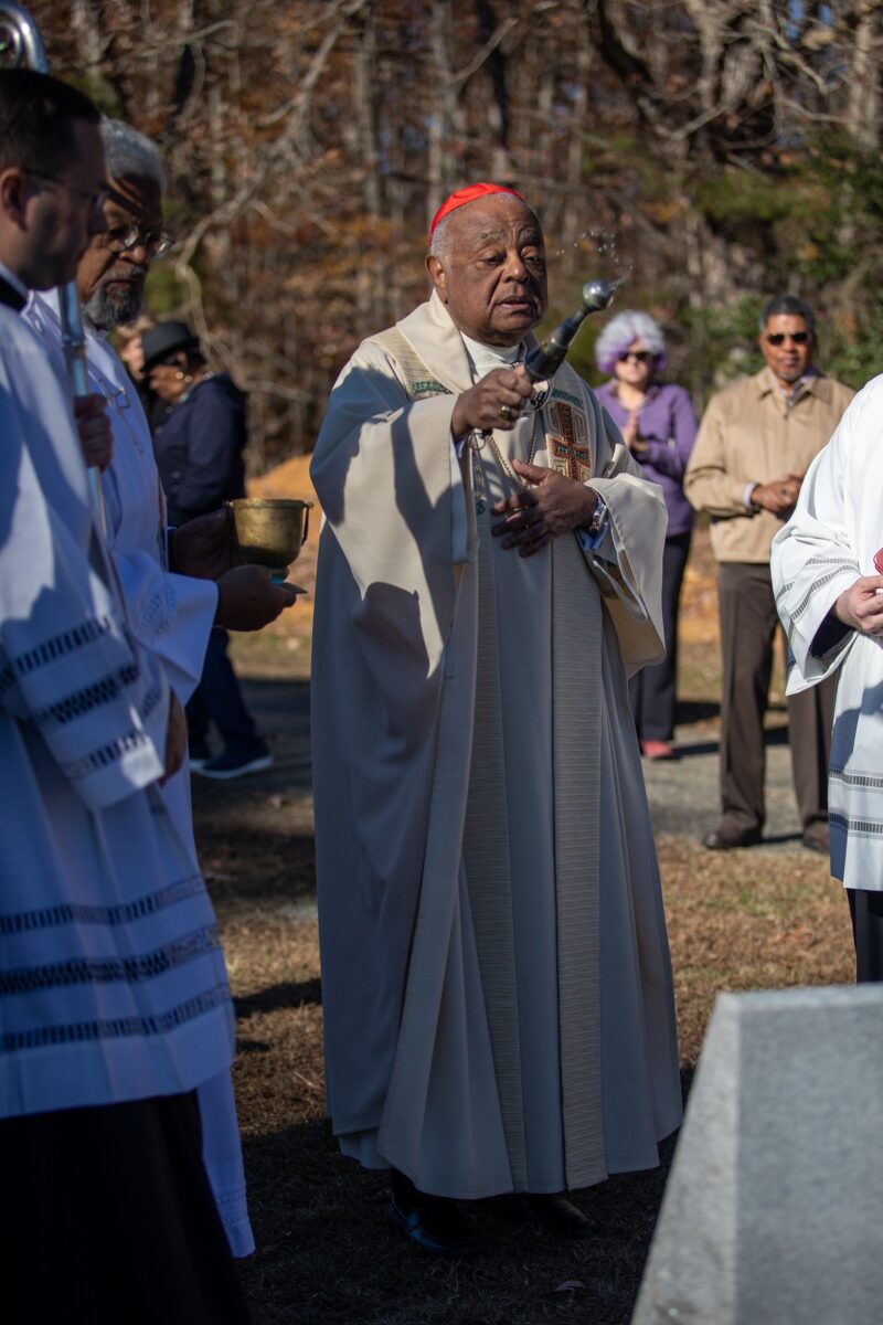 Cardinal Wilton D. Gregory of Washington sprinkles holy water on a ...