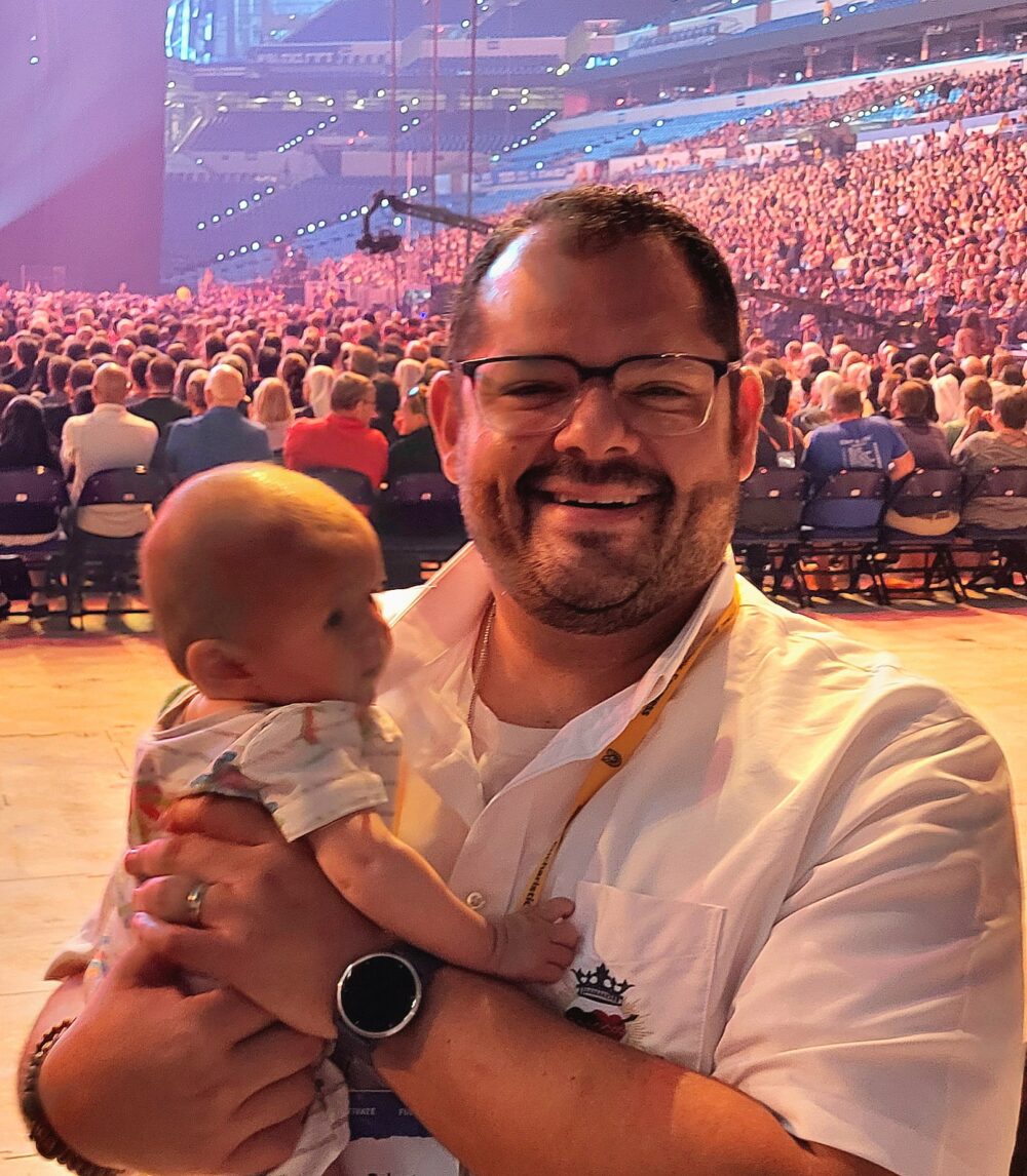 Robert Rojas hold his baby boy, Sebastian, at the National Eucharistic ...